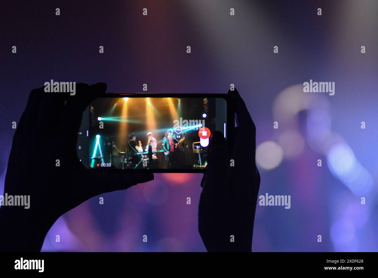 Recording of a concert with the cellphone from the audience Stock Photo ...