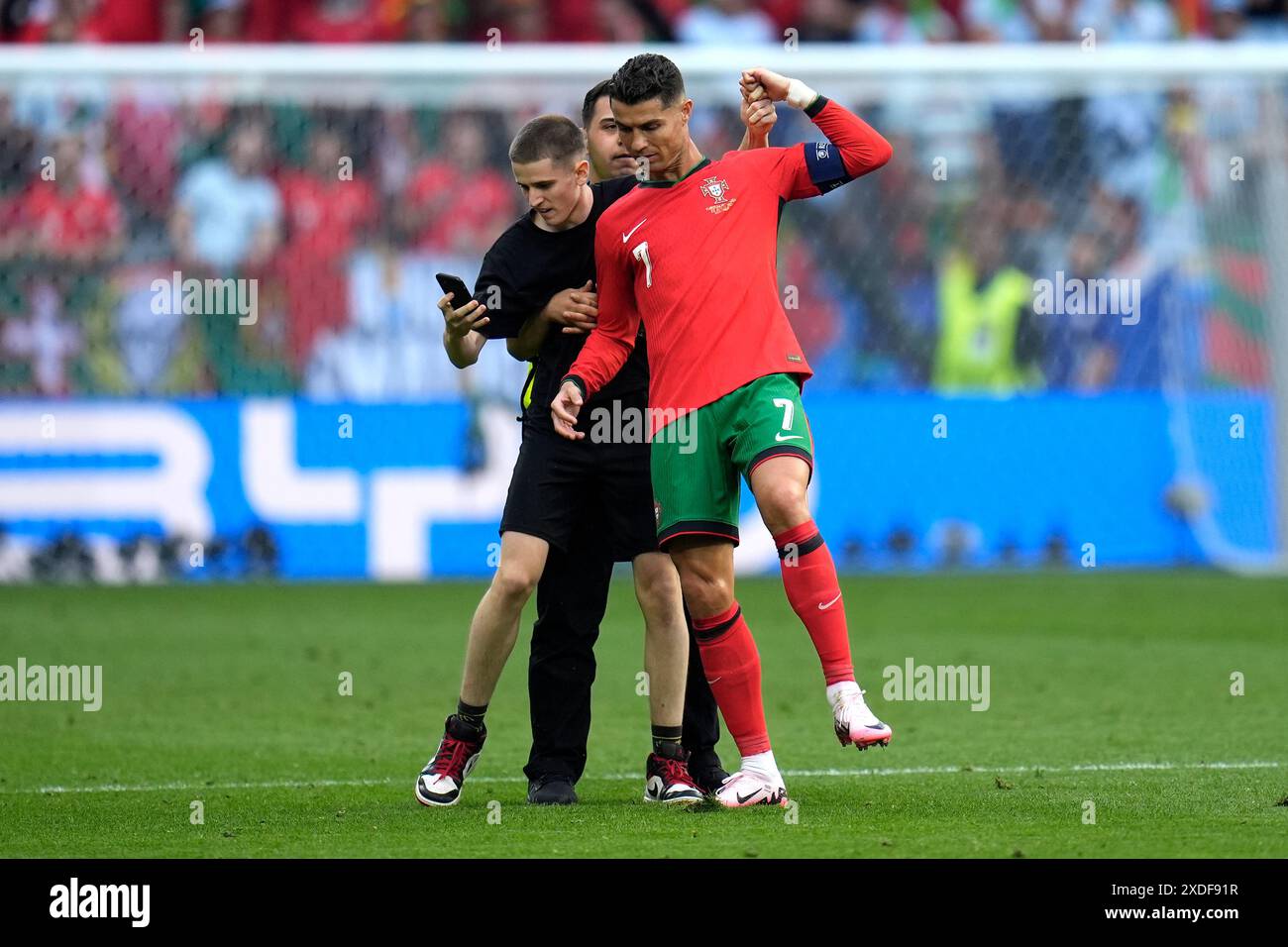 A pitch invader attempts to get a photo with Portugal's Cristiano ...