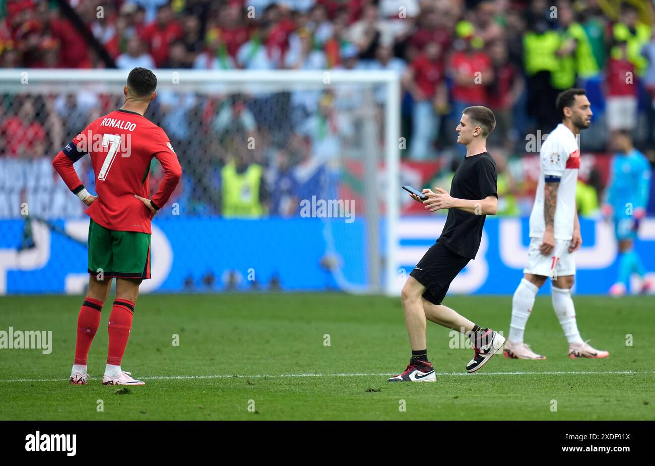 A pitch invader attempts to get a photo with Portugal's Cristiano ...