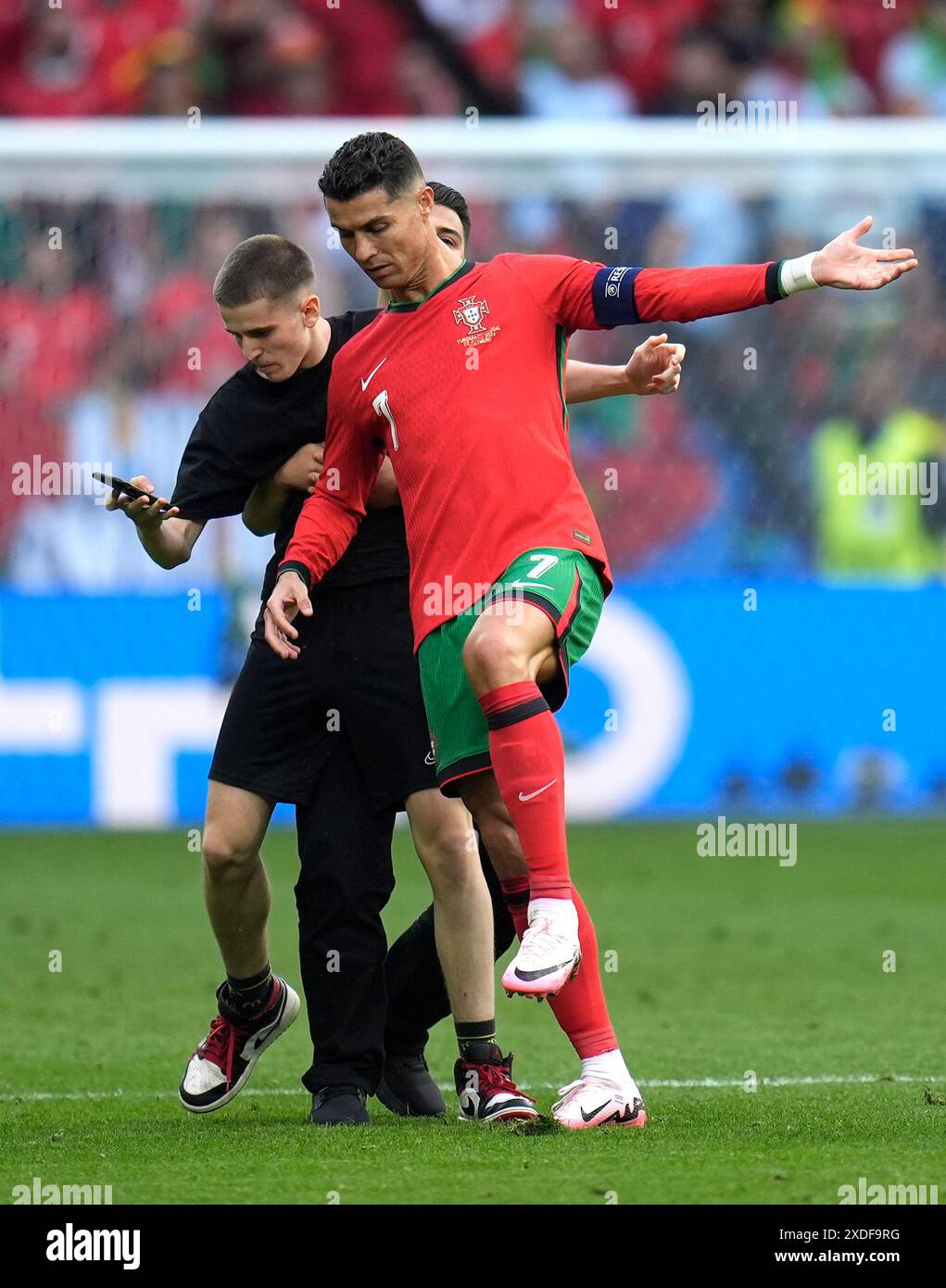 A pitch invader attempts to get a photo with Portugal's Cristiano ...