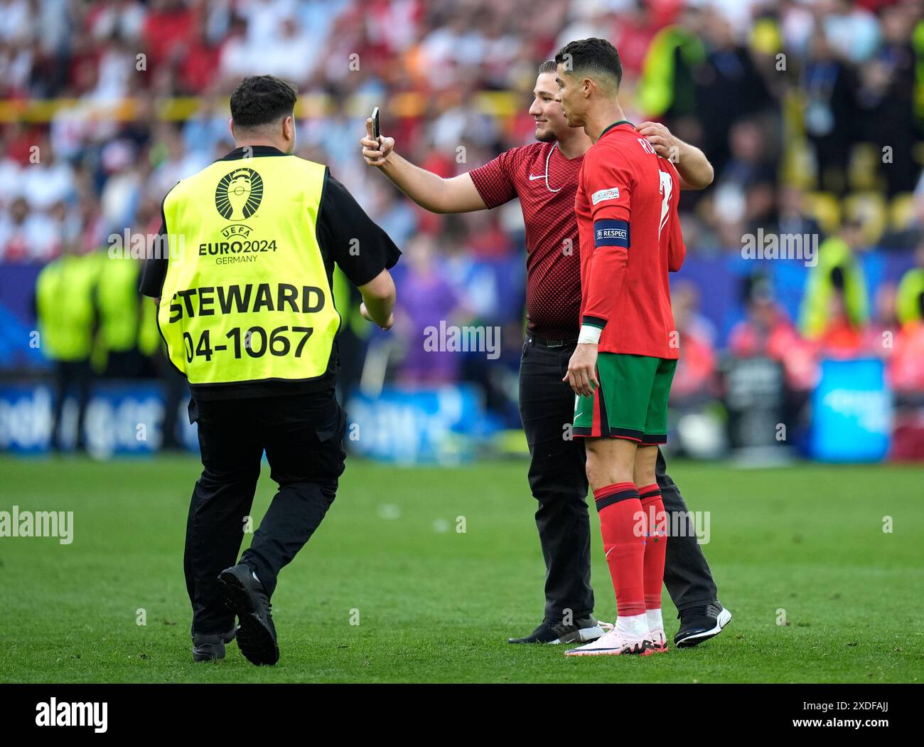 A third pitch invader attempts to get a photo with Portugal's Cristiano ...