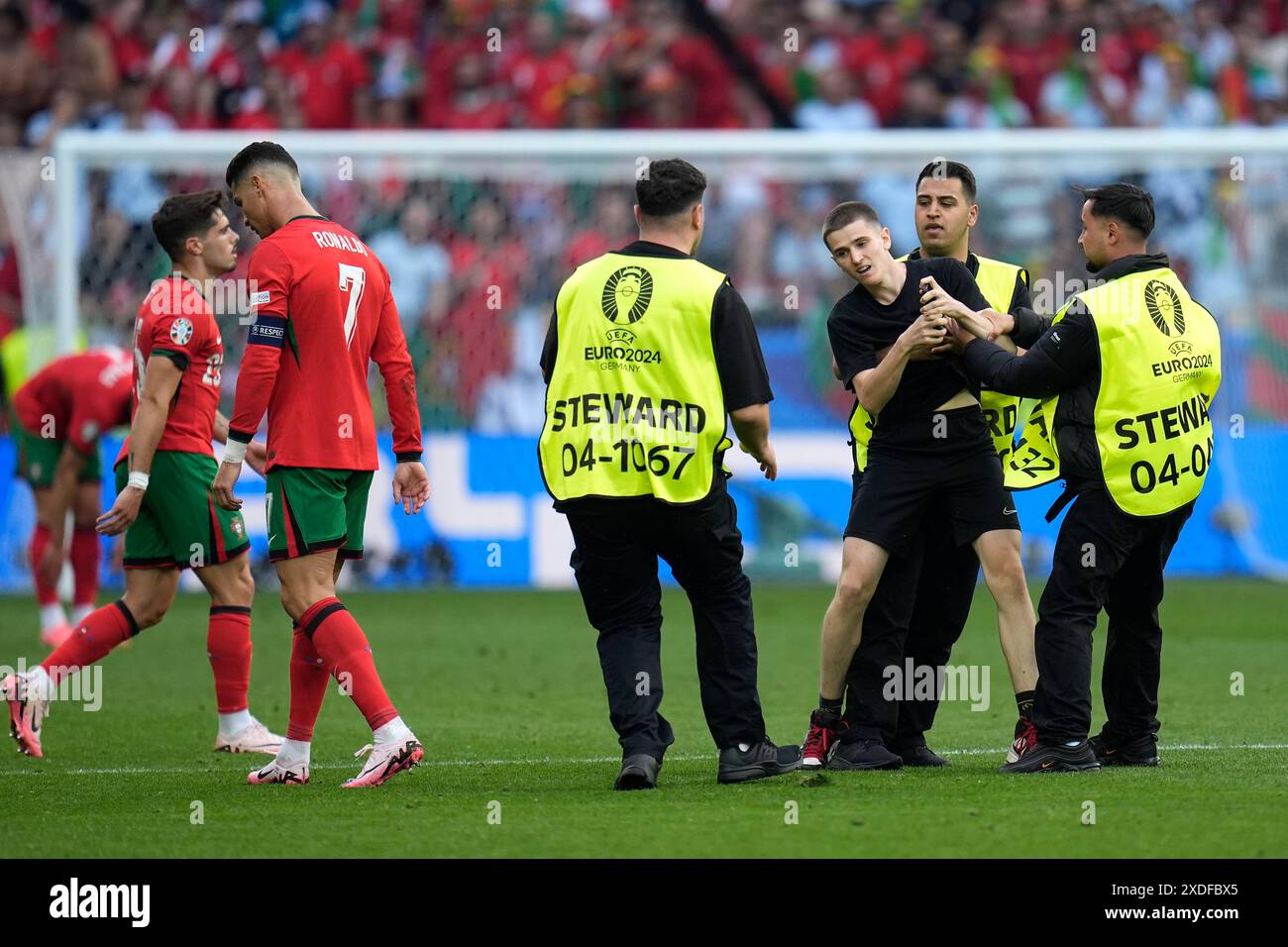 A pitch invader attempts to get a photo with Portugal's Cristiano ...