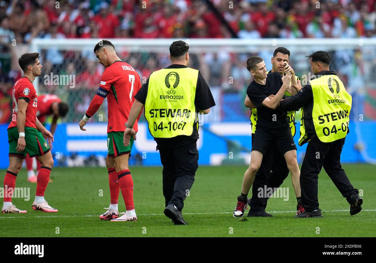 A pitch invader attempts to get a photo with Portugal's Cristiano ...