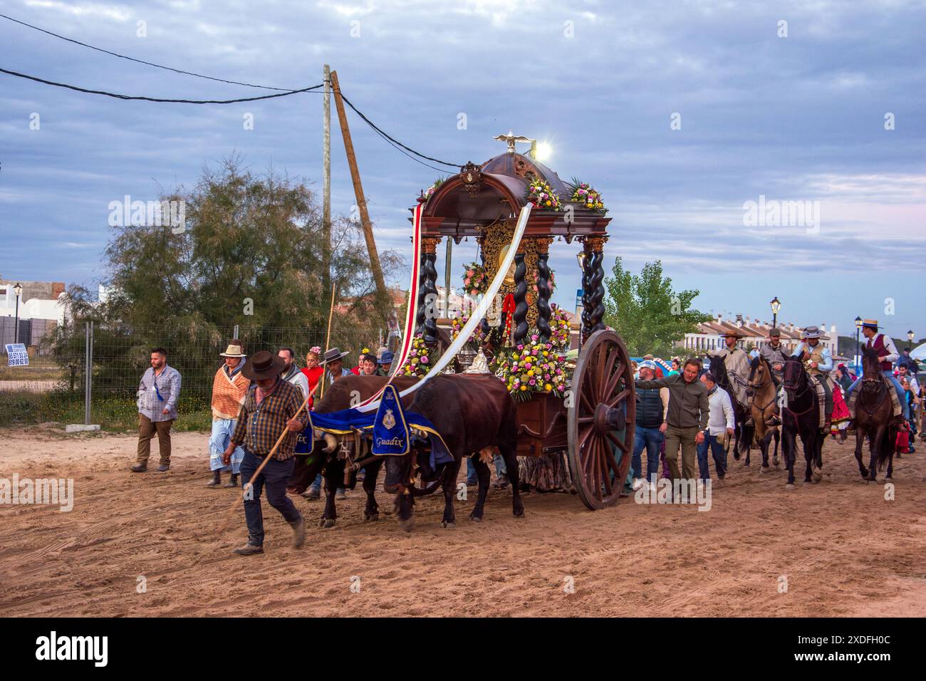 Group of pilgrims on foot following the ox cart at the entrance to ...