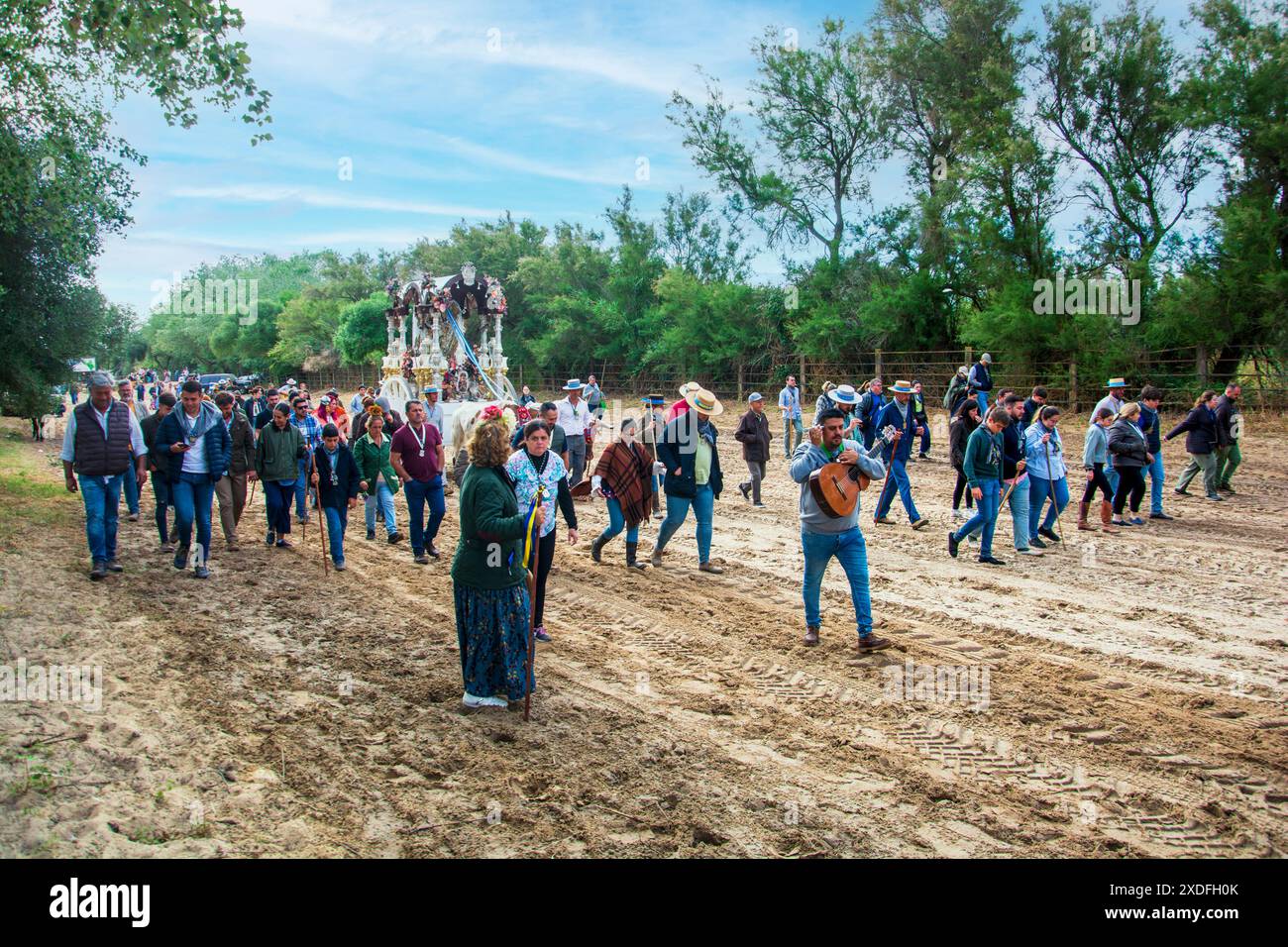 Group of pilgrims on foot following the ox cart at the entrance to ...