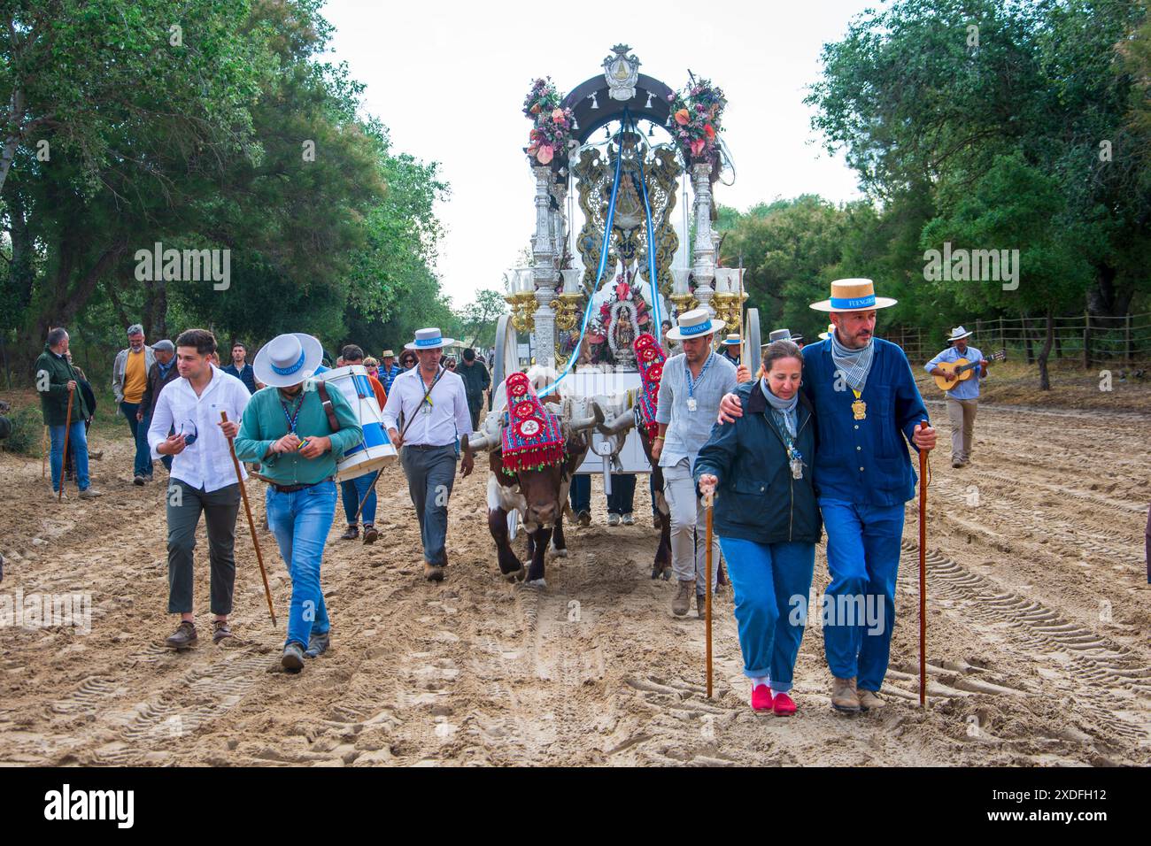 Group of pilgrims on foot following the ox cart at the entrance to ...