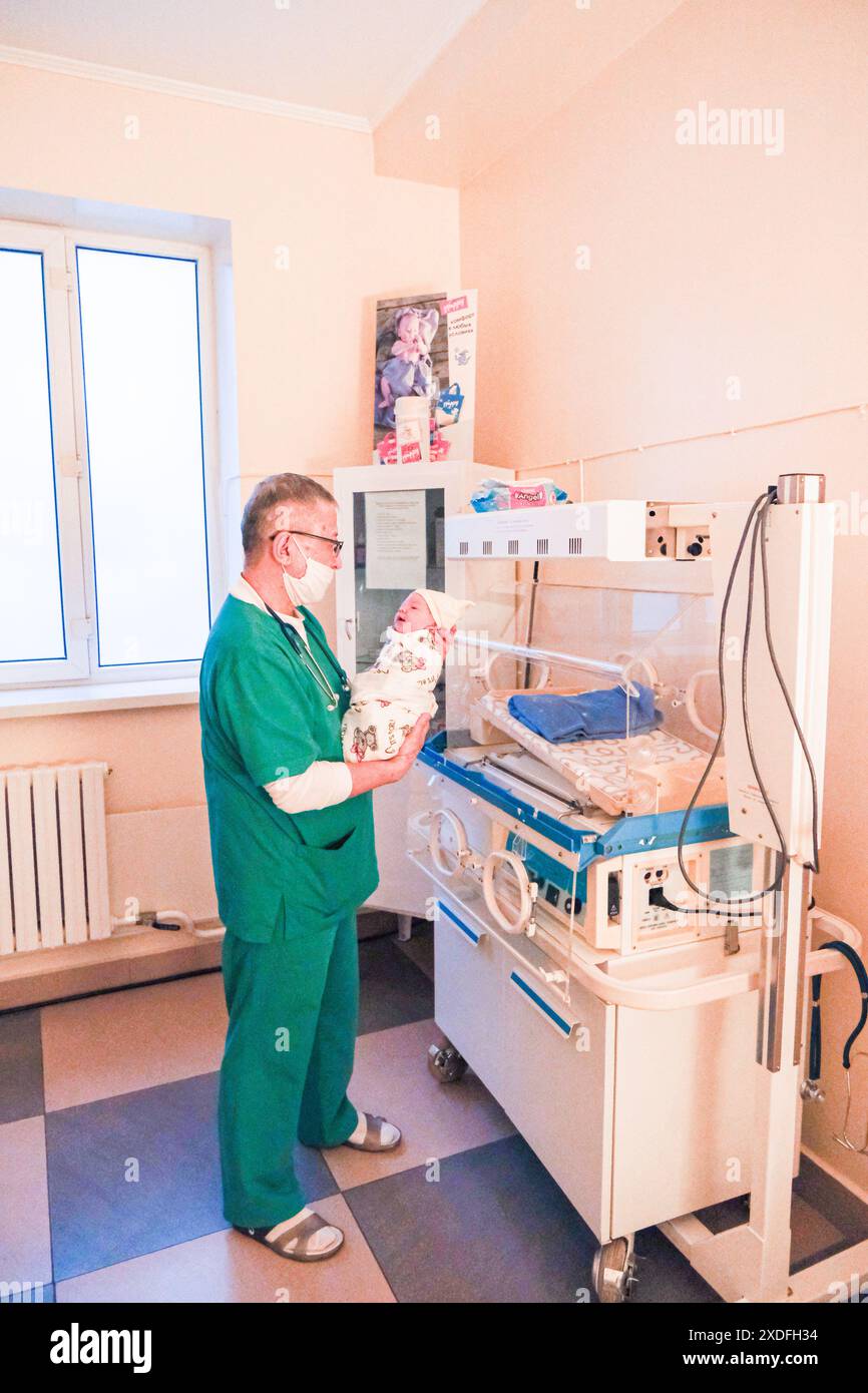neonatologist holding a newborn baby in his arms in the hospital Stock ...