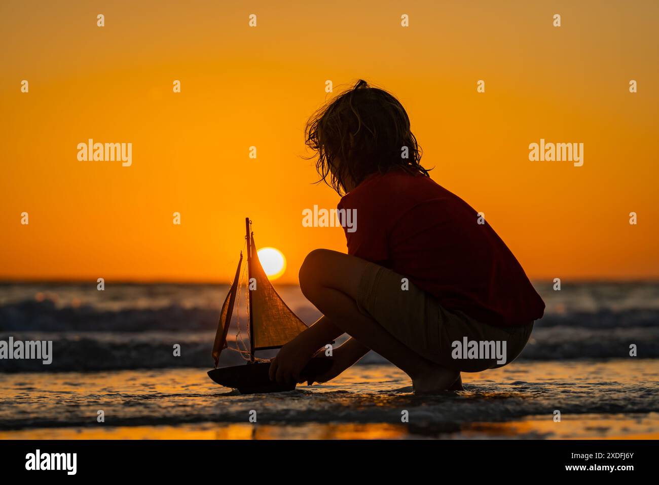 Kid with toy boat in sea water on summer vacation. Little kid playing ...