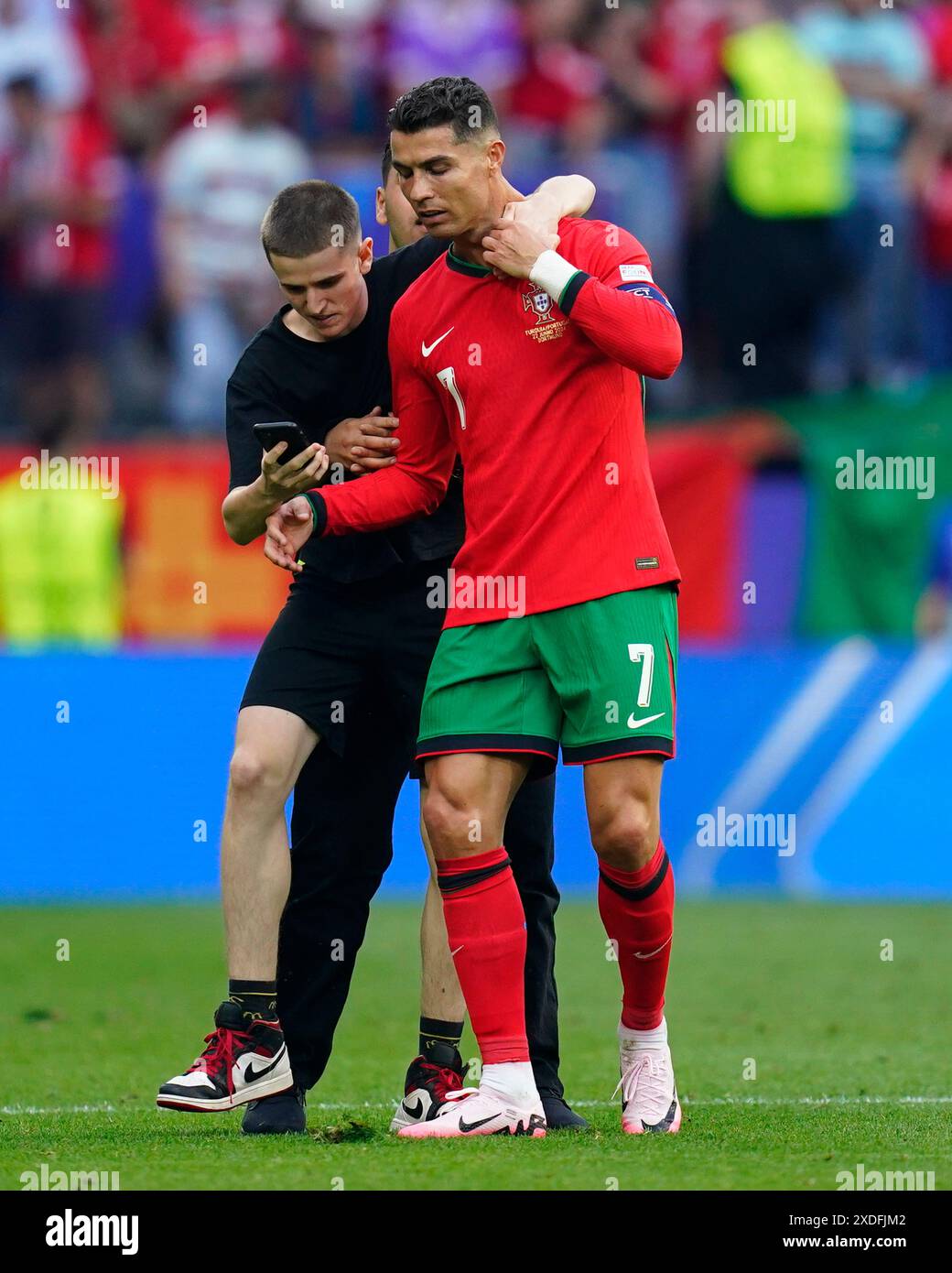 Cristiano Ronaldo of Portugal and fan jumps onto the field during the UEFA Euro 2024 match ...