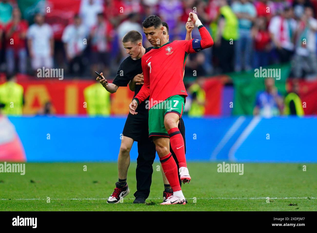 Cristiano Ronaldo of Portugal and fan jumps onto the field during the UEFA Euro 2024 match ...