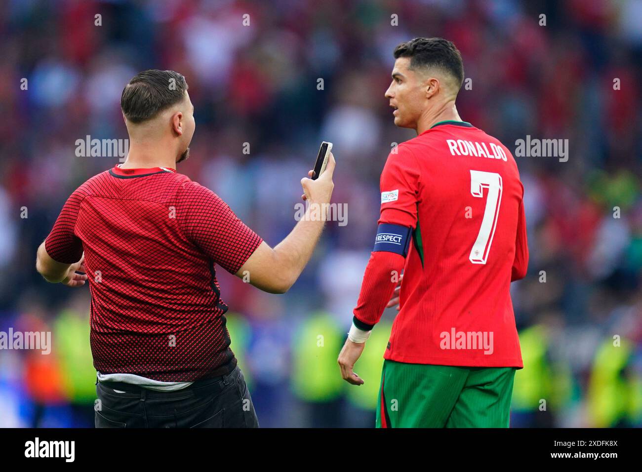 Cristiano Ronaldo of Portugal and fan jumps onto the field during the UEFA Euro 2024 match ...