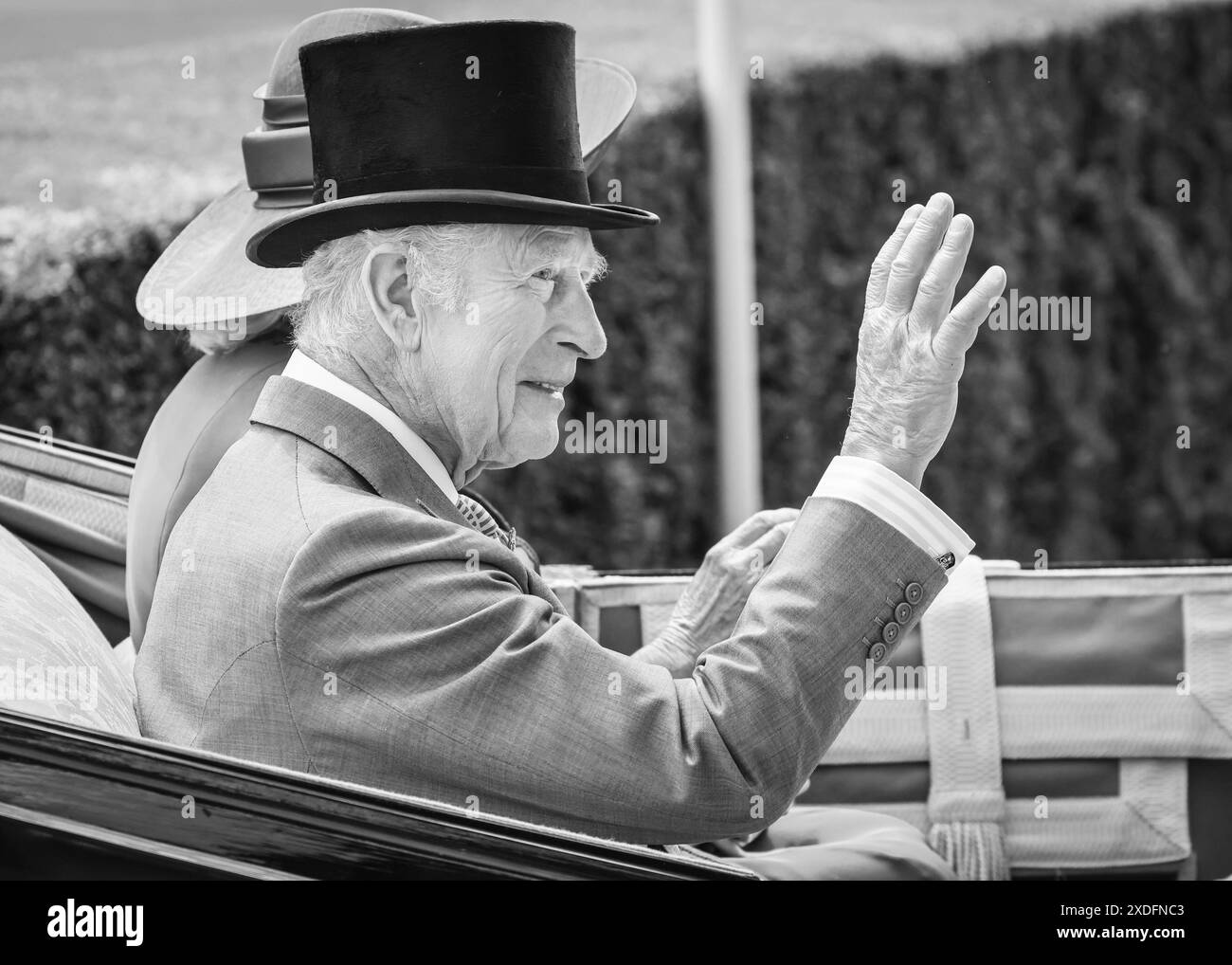 King Charles III, in top hat, smiles and waves from the carriage during ...