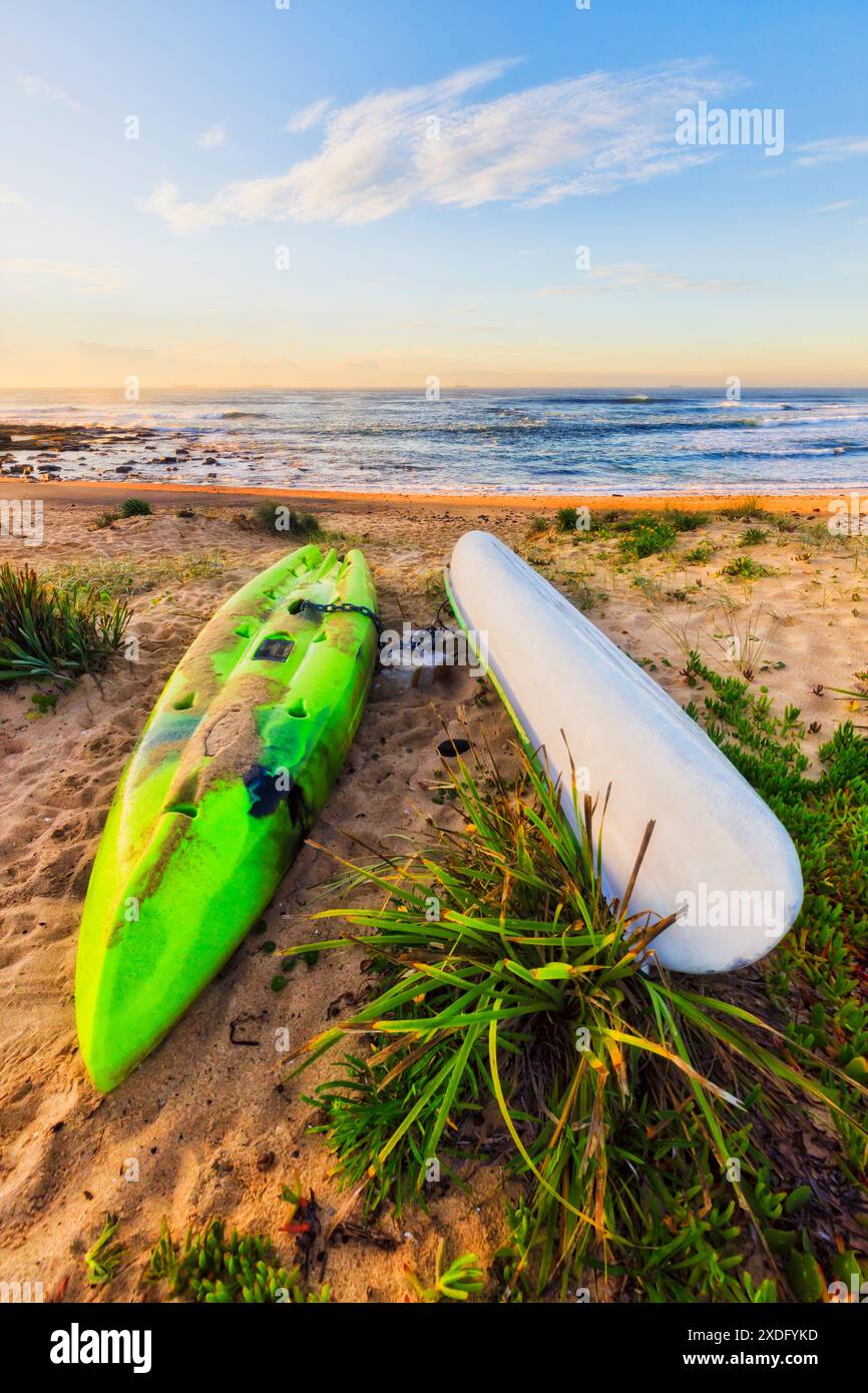 A couple of single canoe on sandy beach in Caves beach coastal town of ...