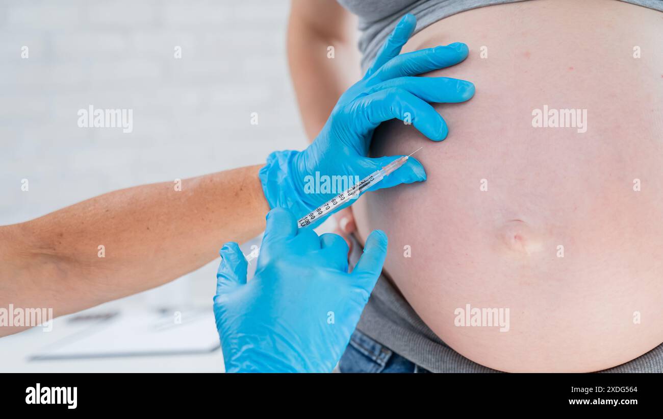 Doctor gives an injection in the stomach of a pregnant woman Stock ...