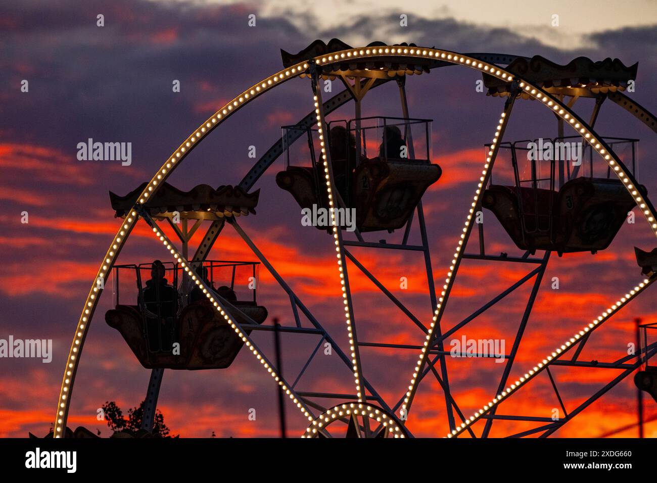 Grimmen, Germany. 22nd June, 2024. The sun sets over a Ferris wheel and ...