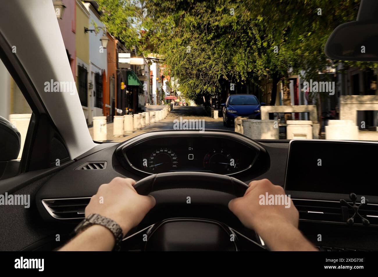 Driving car, view from driver's seat. Man holding hands on steering ...