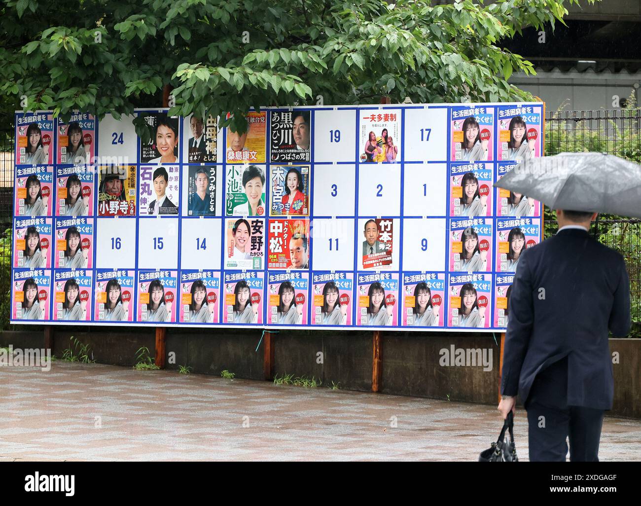 Tokyo, Japan. 21st June, 2024. A man watches posters of Tokyo ...