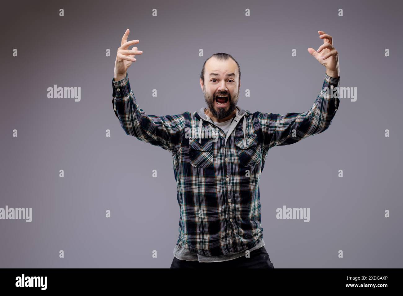 Frustrated man with a beard yells loudly, showing intense anger and ...