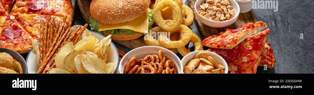 Large table of assorted take out food such as pizza, french fries ...
