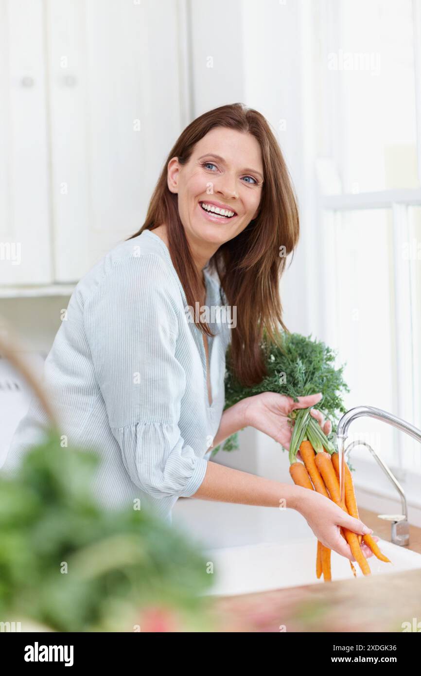 Happiness, woman and healthy food in kitchen for harvest, washing ...