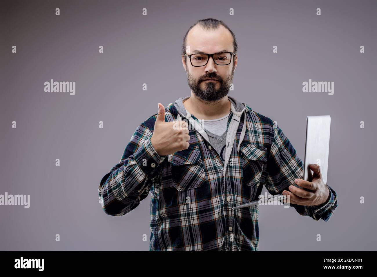 Confident technician holding laptop, giving thumbs up for successful ...