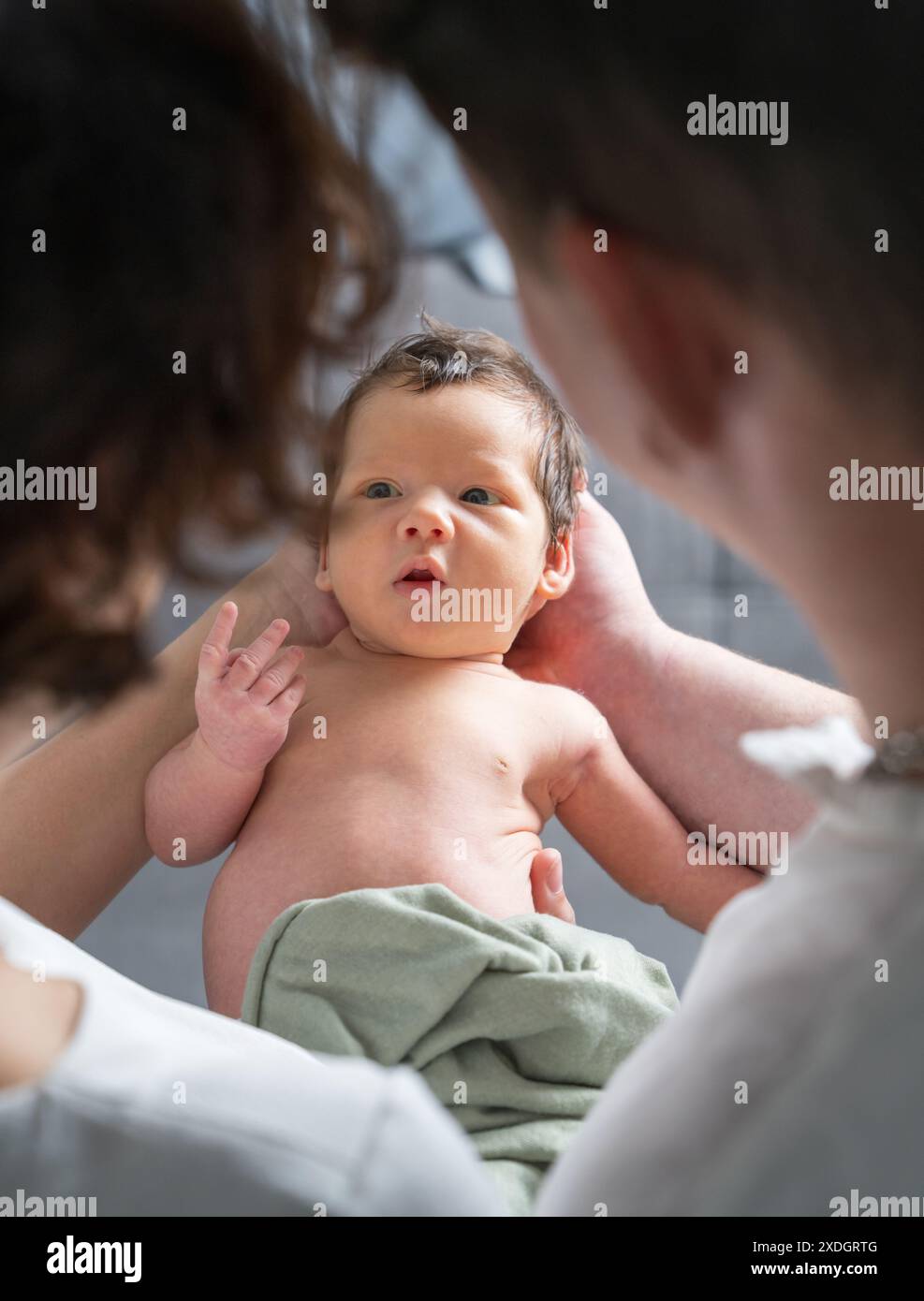 Happy family with a newborn baby. Mom and dad looking tenderly at the ...