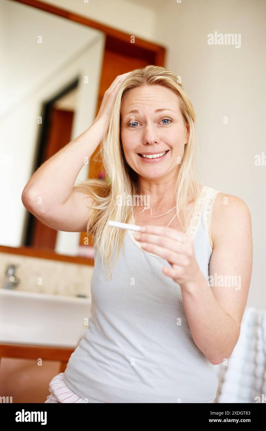 Portrait, pregnancy test or surprise and mature woman in bathroom of ...
