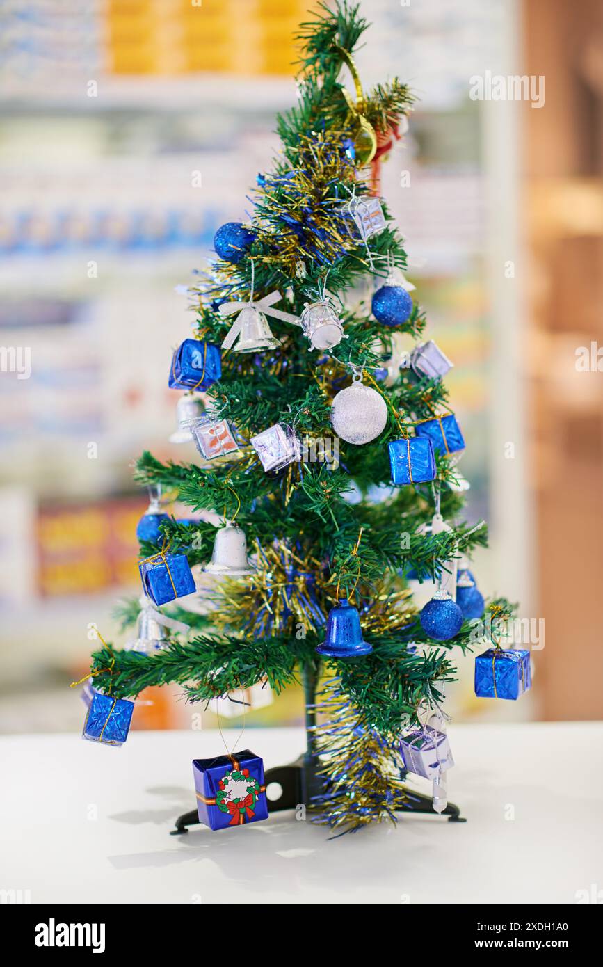 Christmas tree, gifts and decoration at pharmacy, counter and medicine ...