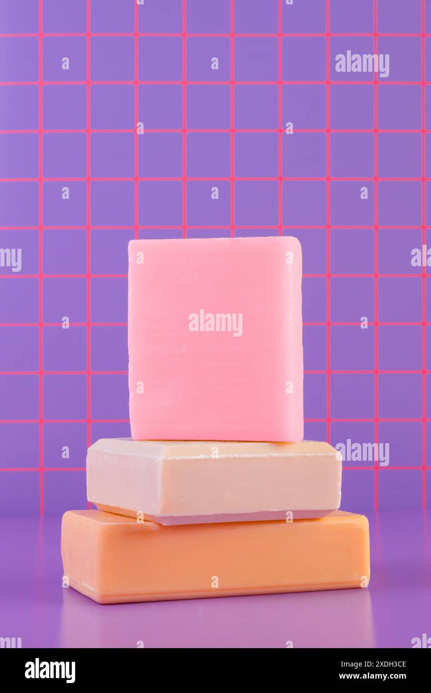 Stacked pastel soaps, trendy and modern, against neon purple-pink tiles ...