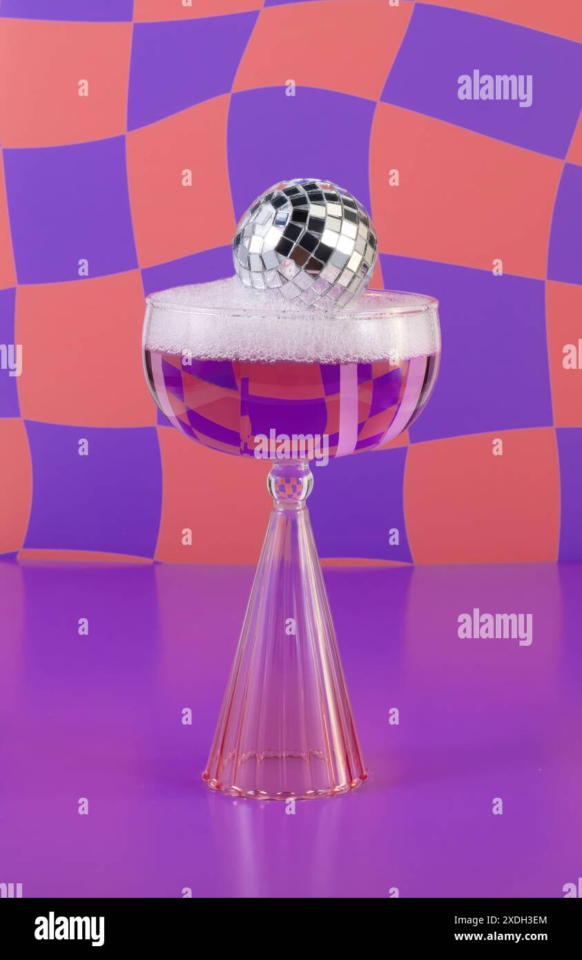 Modern disco ball in a bubble bath champagne glass, bright wavy orange ...