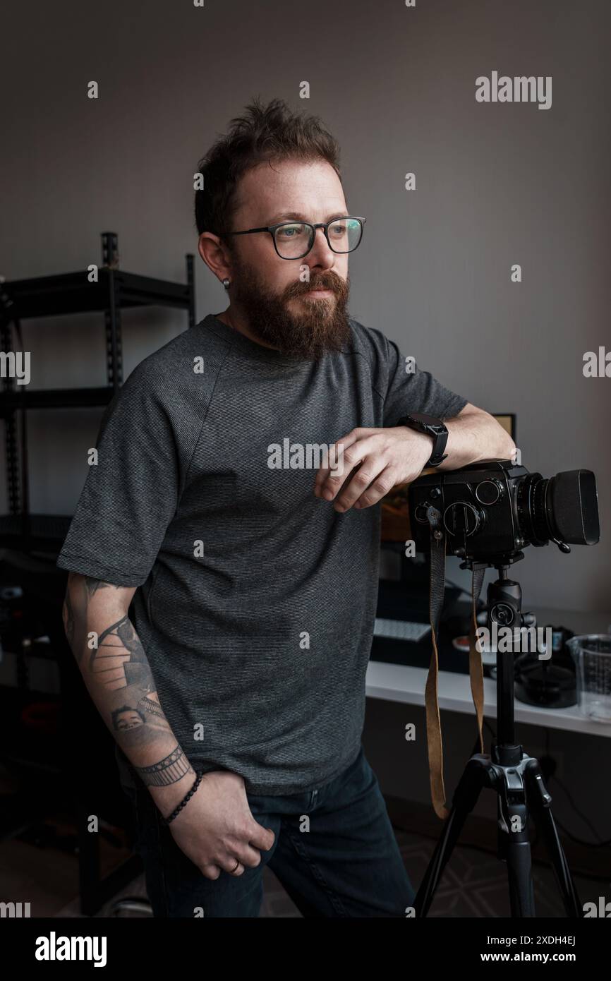 Professional photographer posing with camera on tripod Stock Photo - Alamy