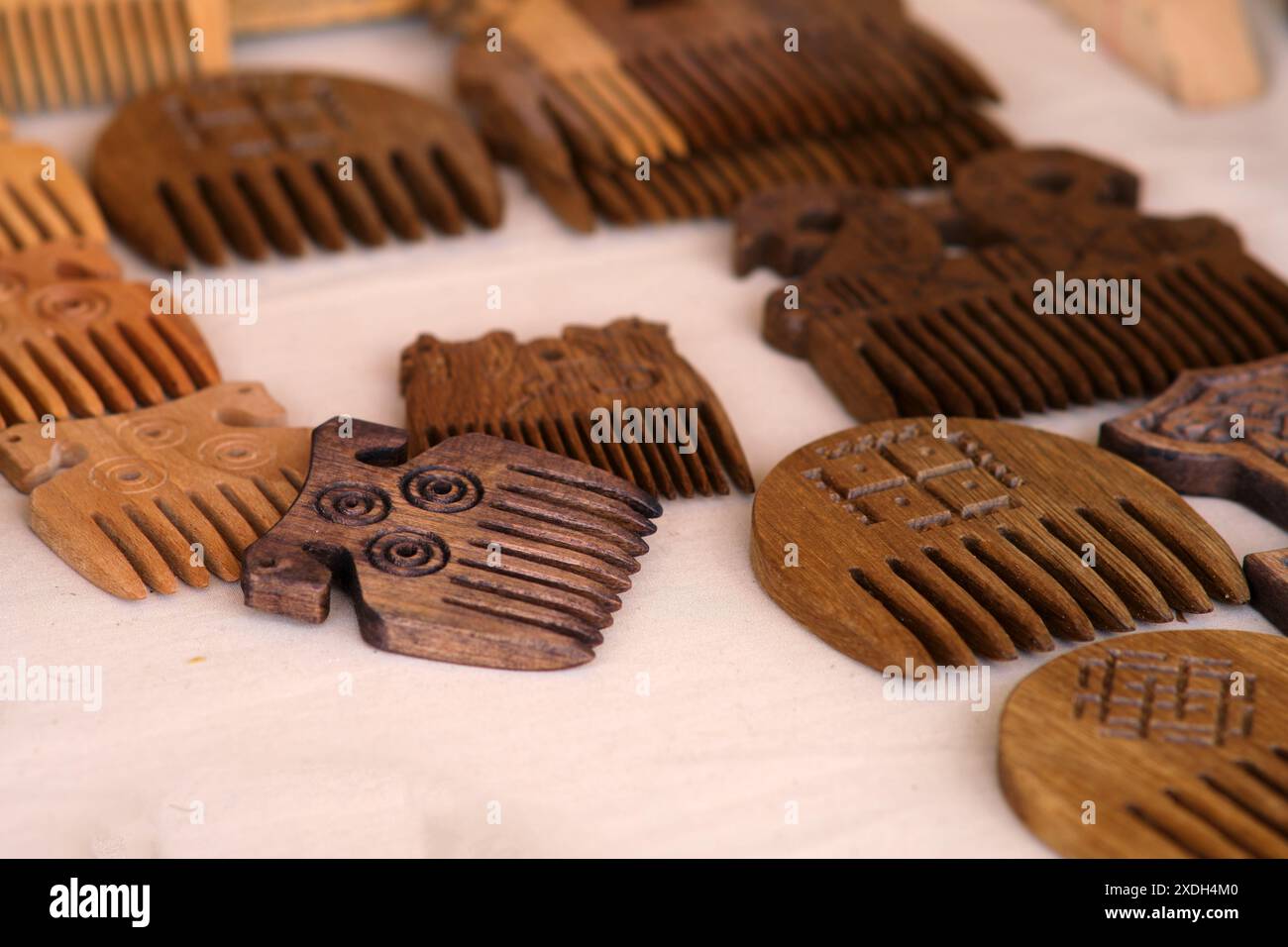 A collection of wooden hair combs with various designs and patterns ...