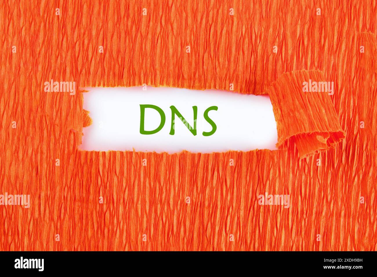 DNS (Domain Name System) acronym. DNS on white under the paper Stock ...