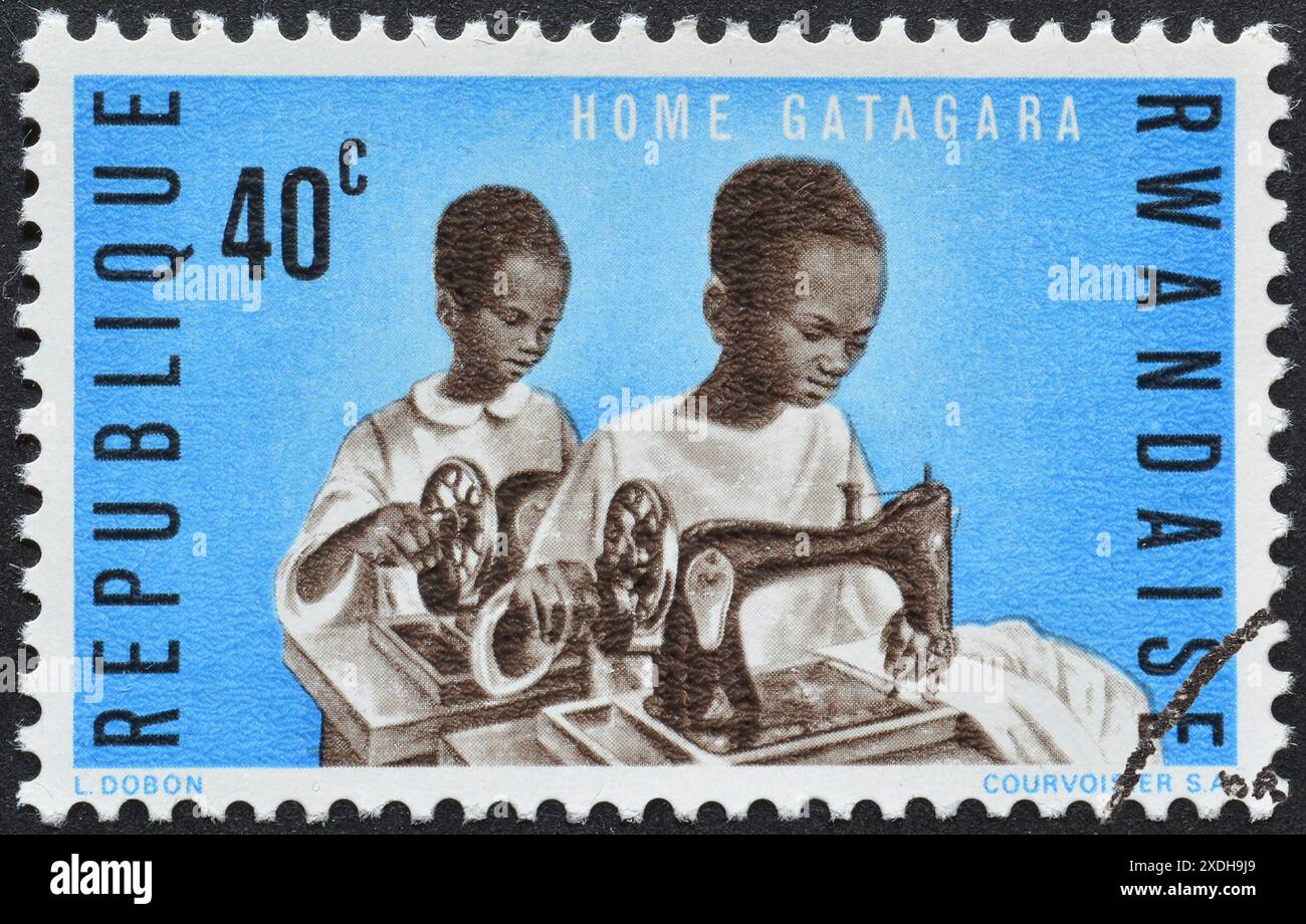 Cancelled postage stamp printed by Rwanda, that shows Girls sewing ...