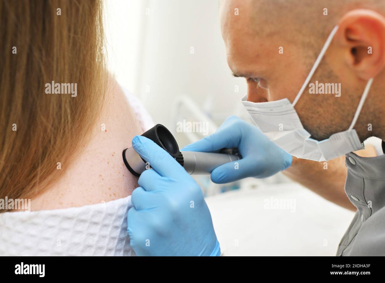dermatologist oncologist uses a dermatoscope to examine moles and ...