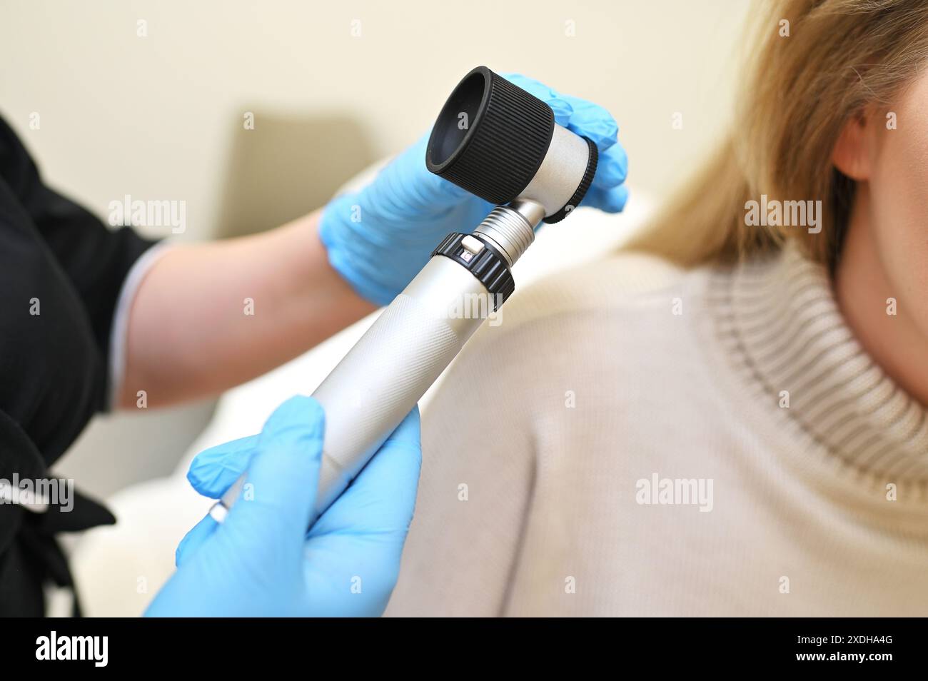 dermatologist holds a dermatoscope in his hands and examines the ...