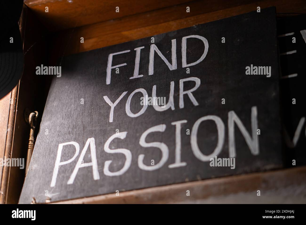 A close-up of a black sign with white text that reads FIND YOUR PASSION ...