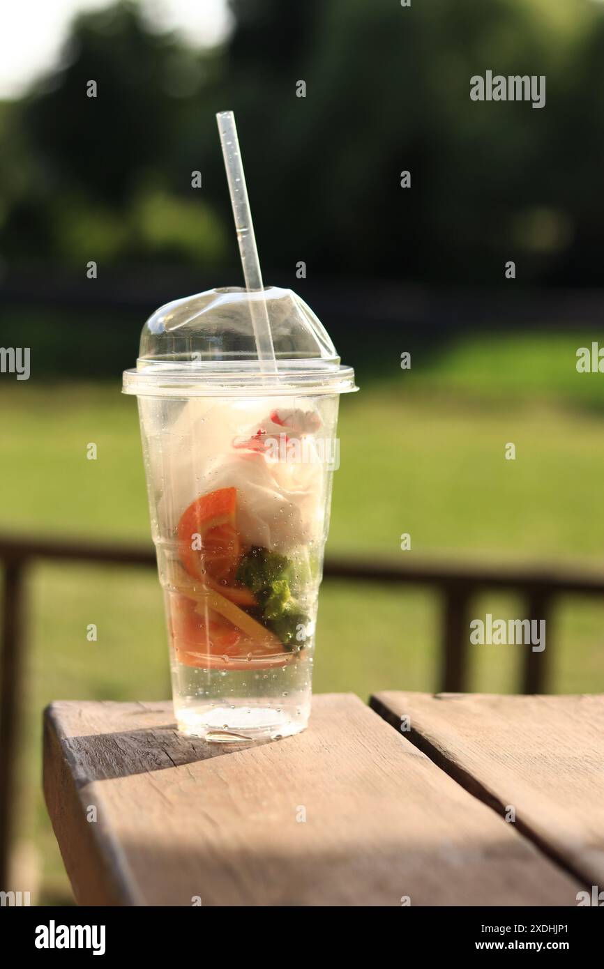 Plastic disposable cup with trash inside, close-up. Improper disposal ...