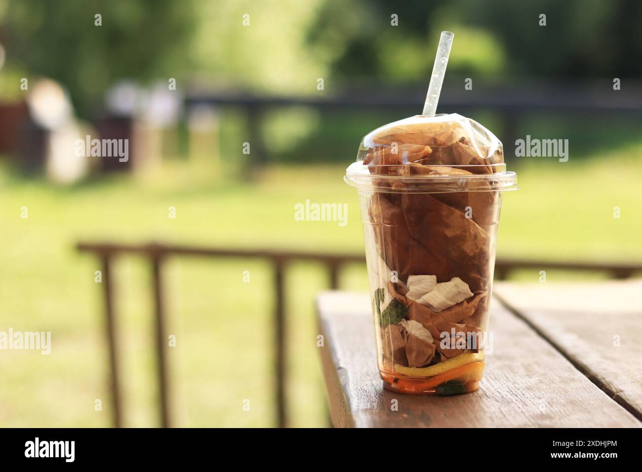 Plastic disposable cup with trash inside, close-up. Improper disposal ...