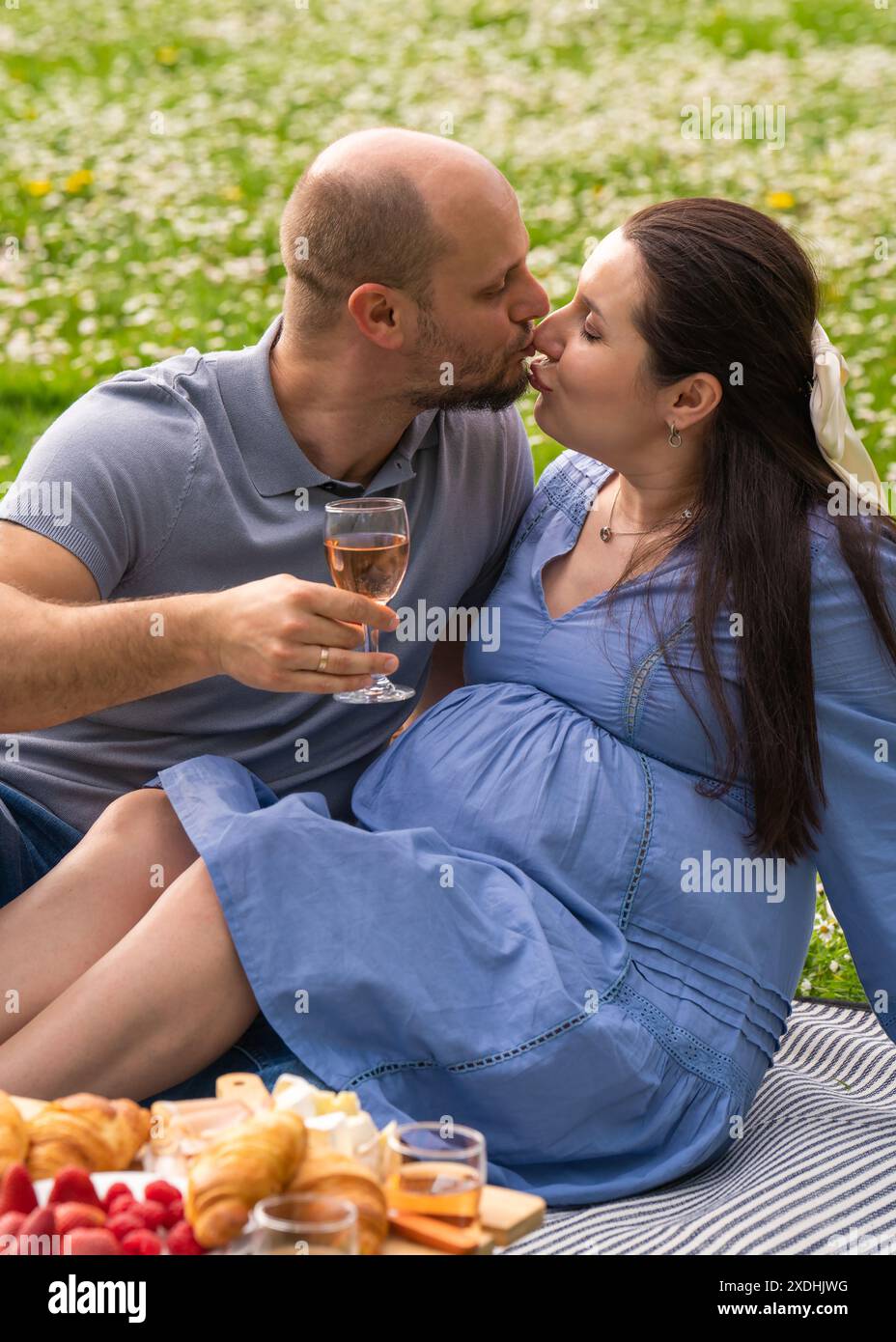 Happy pregnant couple spending time together on a picnic outdoors. A ...