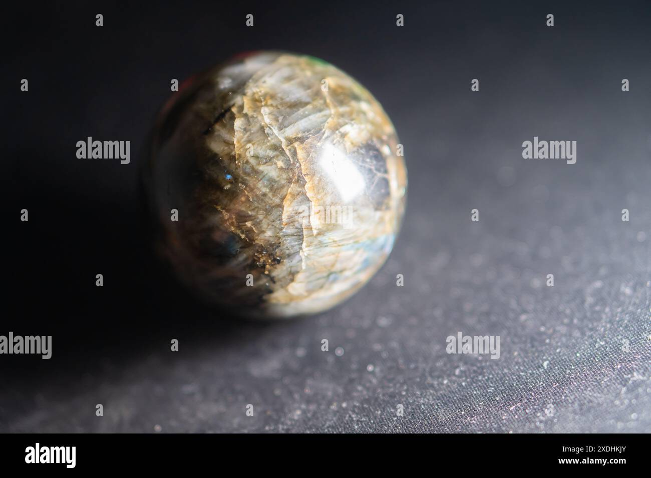Close-up of a polished Labradorian sphere with iridescent colors on a ...