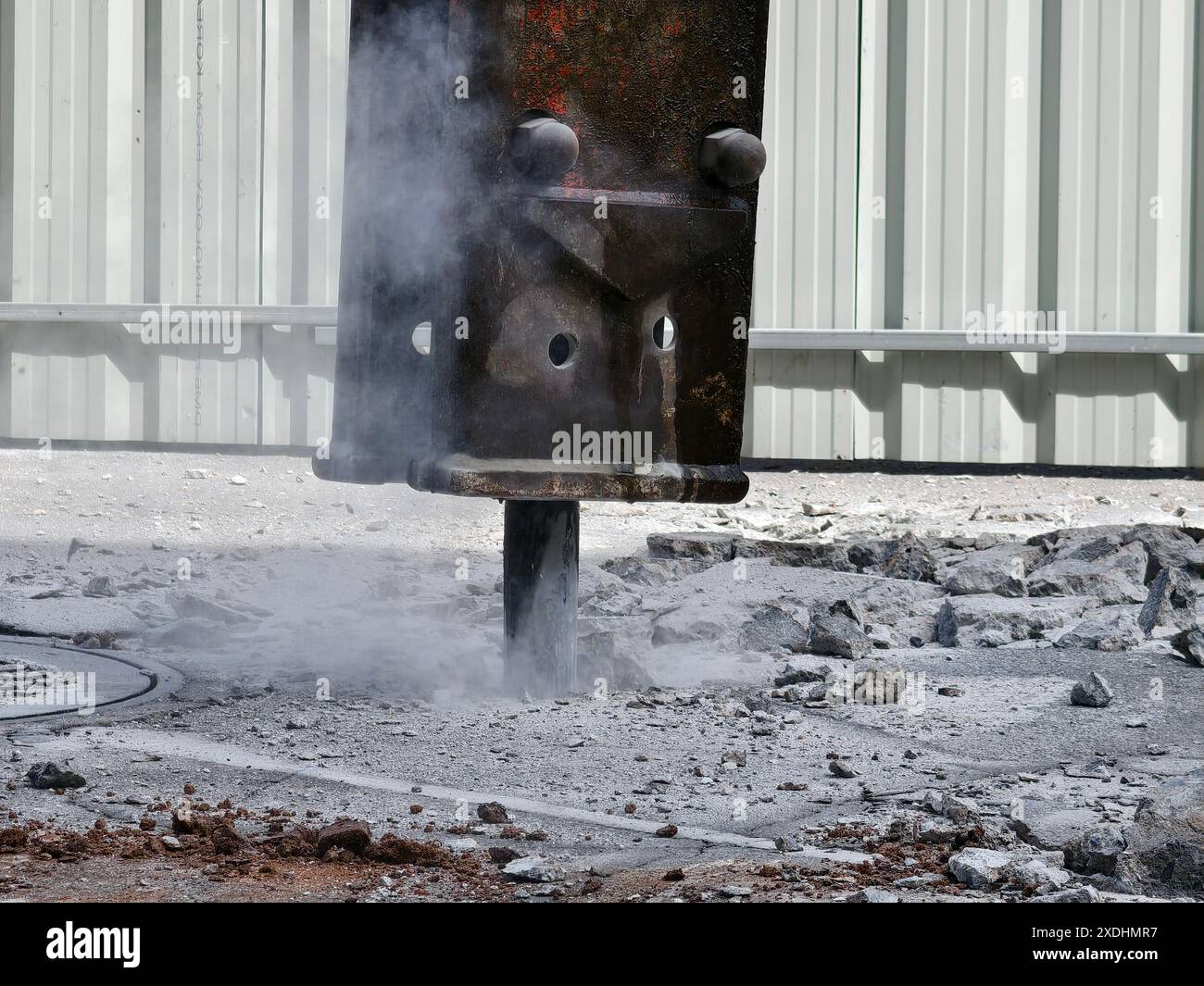 A hydraulic hammer breaking concrete at a construction site Stock Photo ...
