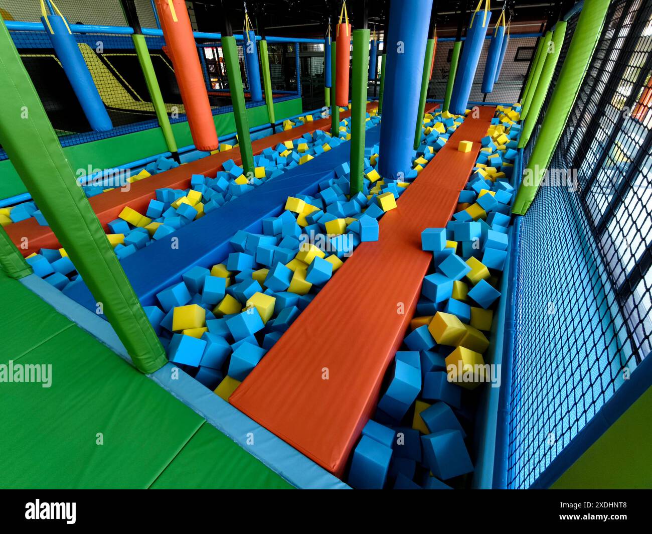 Trampoline park has blue and yellow foam cubes for kids fun Stock Photo ...