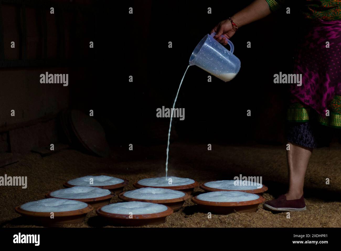 Bhaktapur, Nepal. 23rd June, 2024. A Nepalese woman pours hot boiled ...