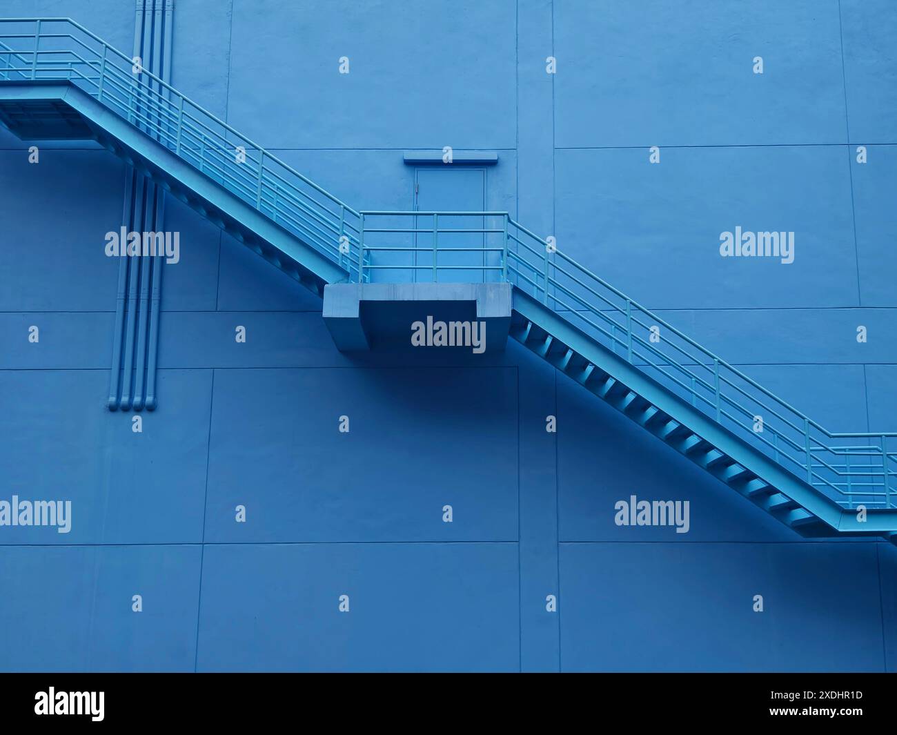 A set of stairs ascending a large blue wall Stock Photo - Alamy