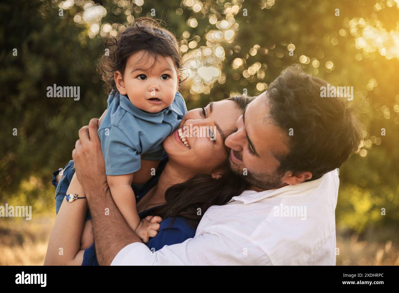 A joyful family moment with a father, mother in a blue dress, and their ...