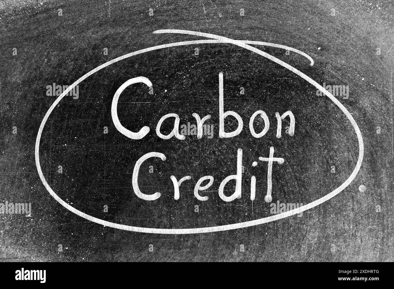 White chalk hand writing in word carbon credit and circle shape on ...