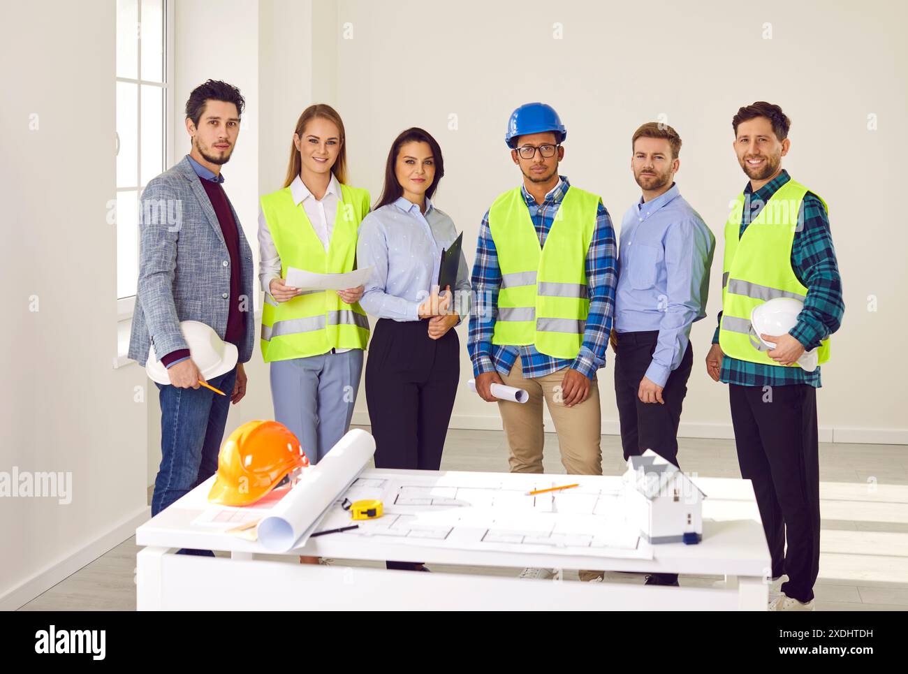 Team of architects, engineers and builders standing by office table ...