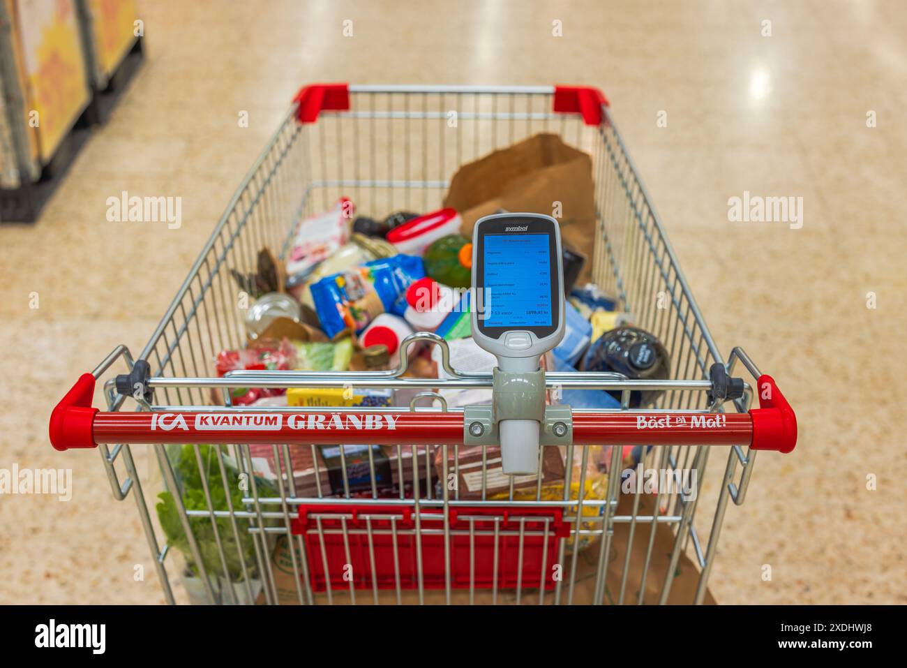 Close-up view of shopping cart filled with groceries and barcode ...