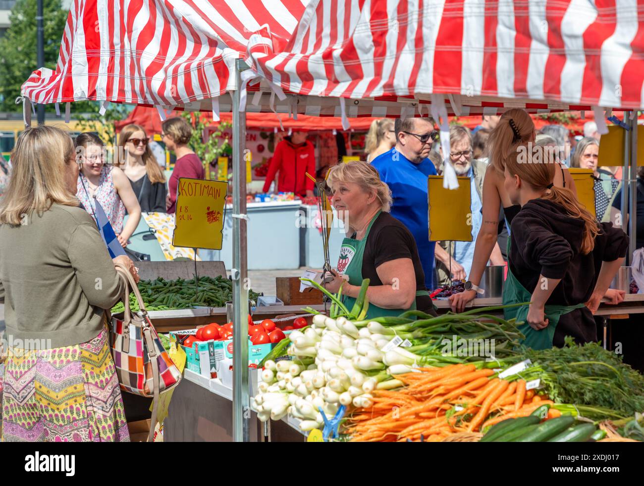 Greengrocer in a candy-cane market tent in the Hakaniemi square ...